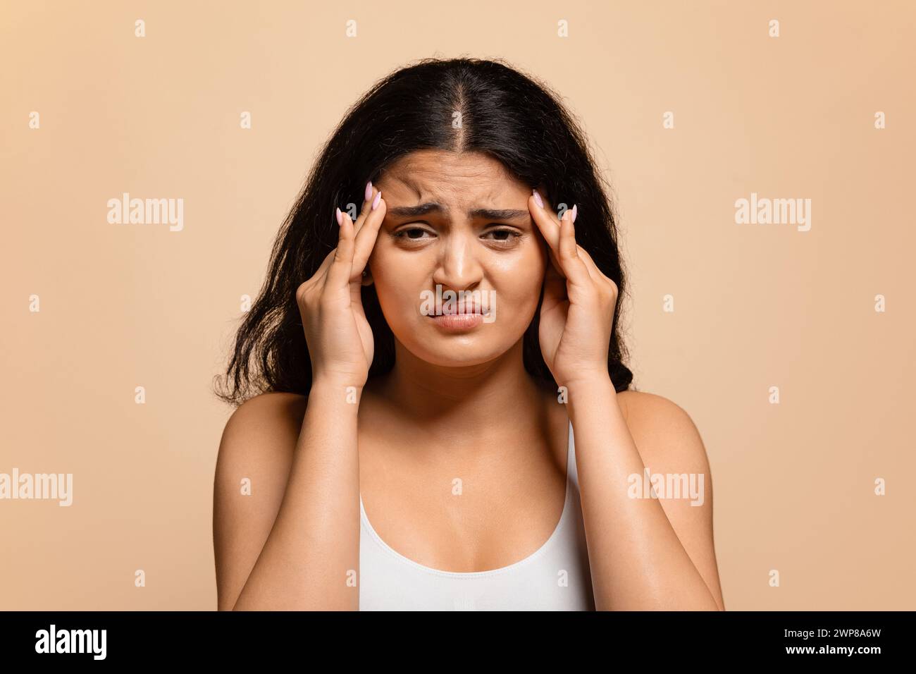 Headache Concept. Stressed indian woman in white top touching her ...