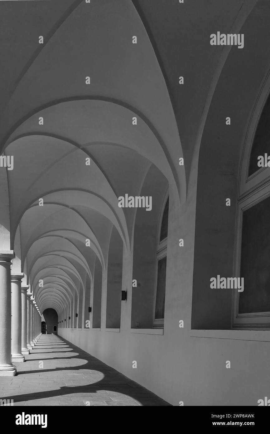 A shadow of a bench cast on a walkway under arches in Dresden, Germany ...
