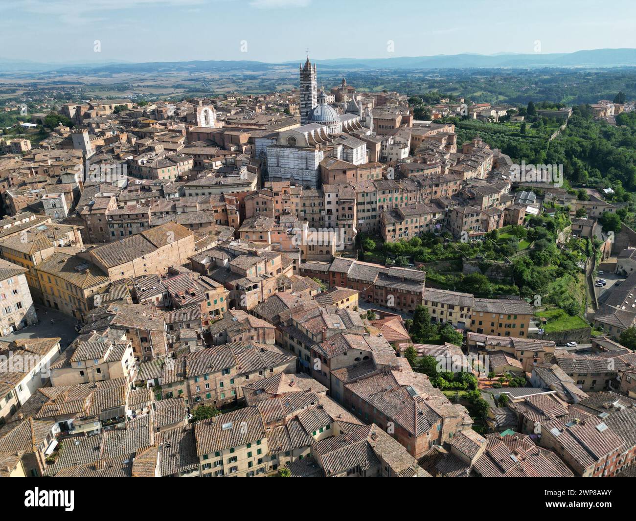 An aerial view of city with historic buildings and lush trees in ...
