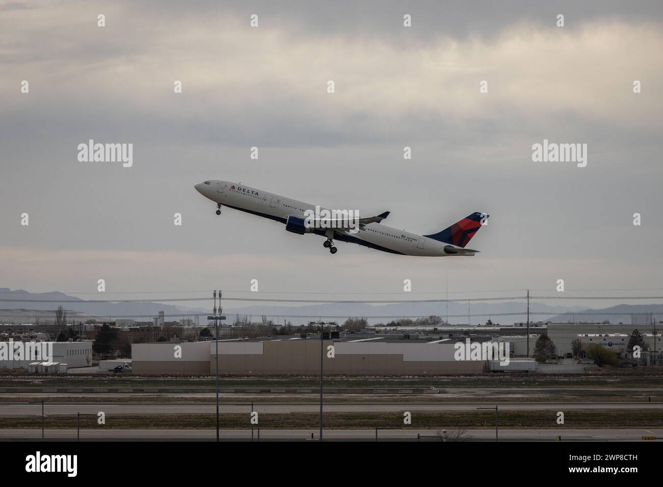 An airplane ascending from a runway at an airport Stock Photo - Alamy