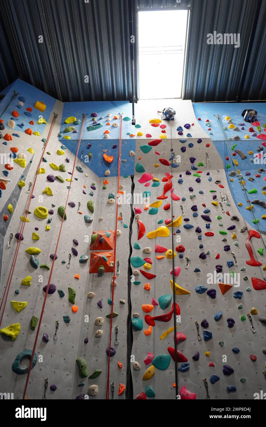 Indoor rock climber scaling boulder wall in building Stock Photo - Alamy