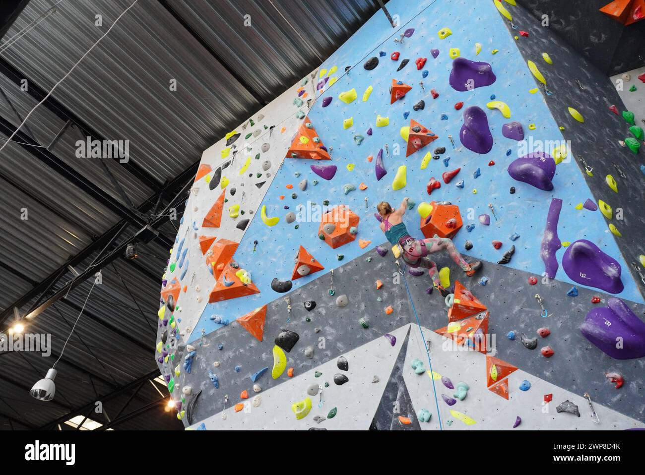 A towering climbing wall with colorful boulder walls behind Stock Photo ...