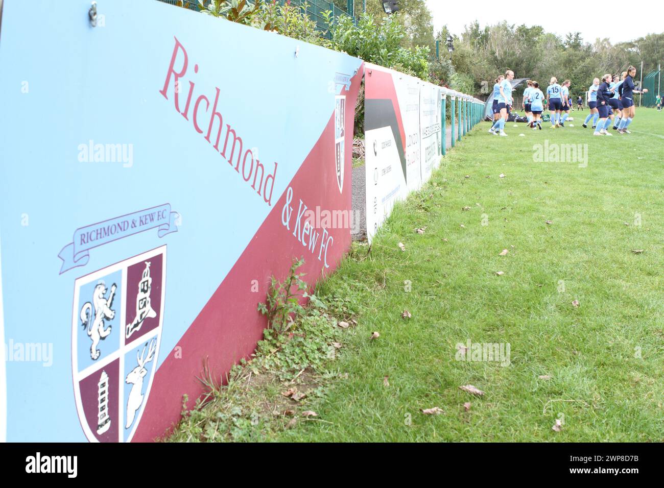 Badge and team colours on board at enge of pitch Richmond and Kew Women ...