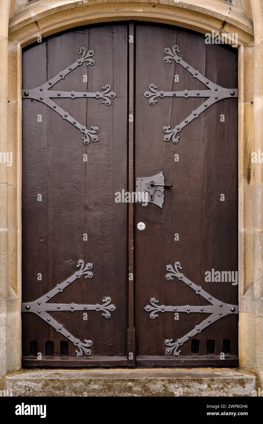 Stone building's wooden doors with intricate wrought designs ajar Stock ...