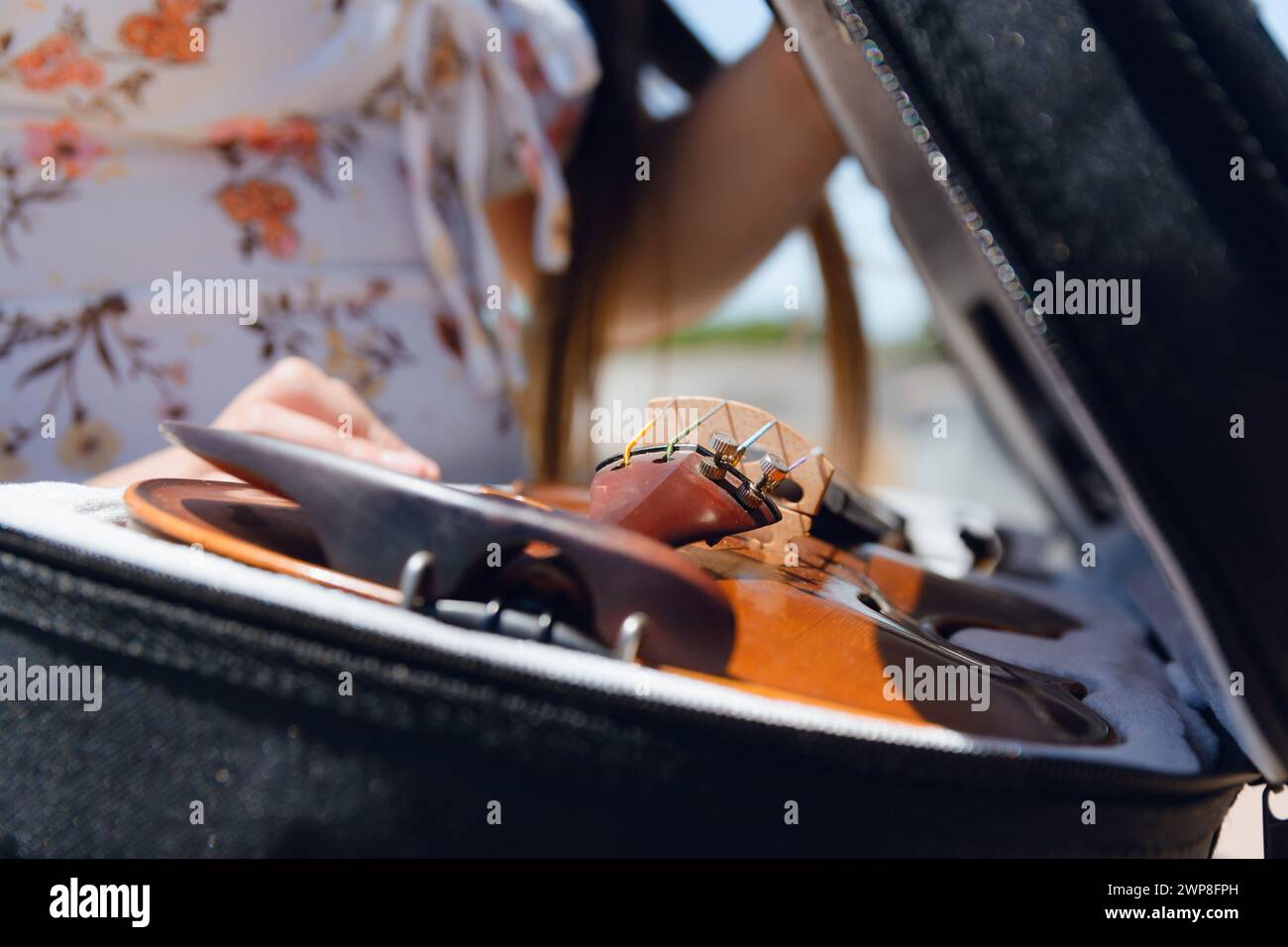closeup of unrecognizable caucasian woman on street closing violin case ...