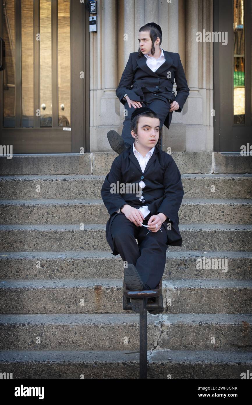 On a warm winter day, 2 hasidic yeshiva students relax during recess on ...
