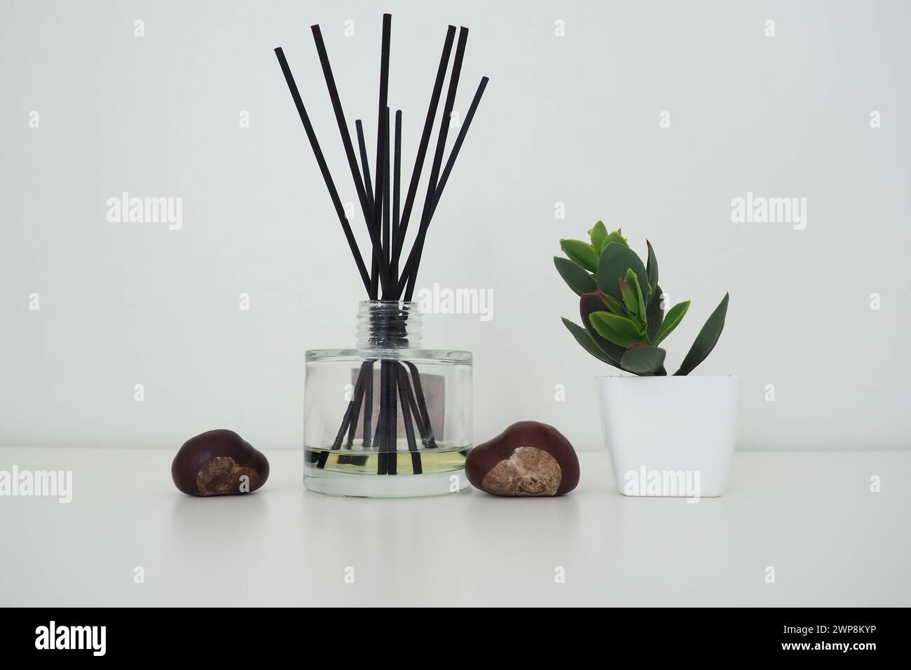 Incense sticks are dipped into a glass cubic vessel with essential oils ...