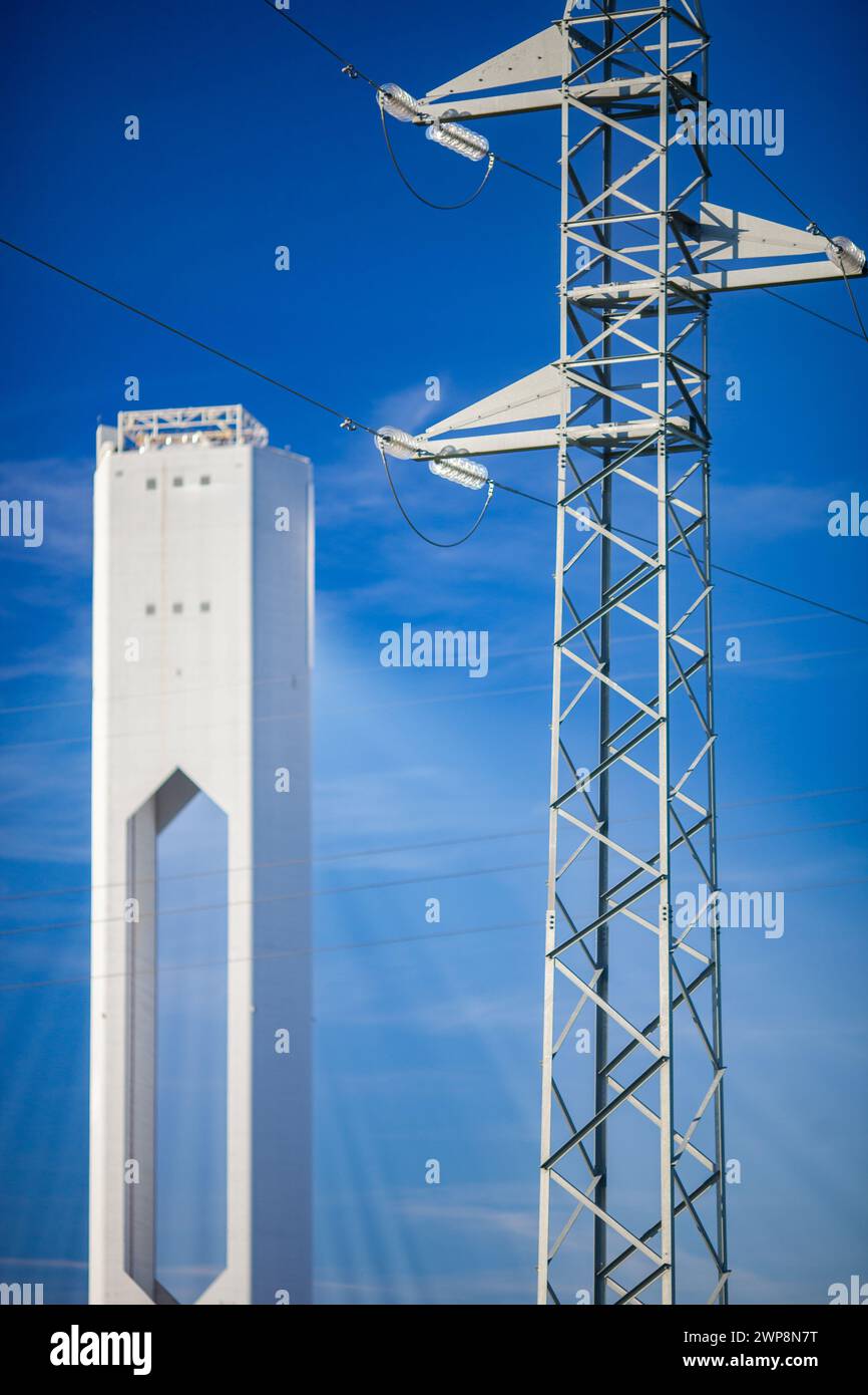 High tension electrical lines running adjacent to a towering solar ...