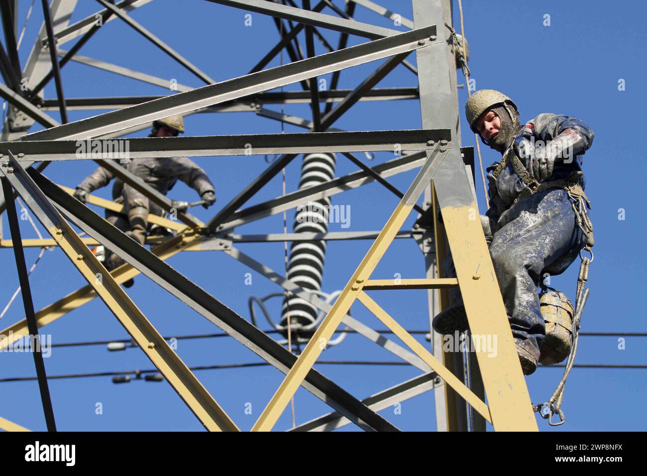 29/11/12 Workmen paint high voltage electricity pylons near Alderley ...