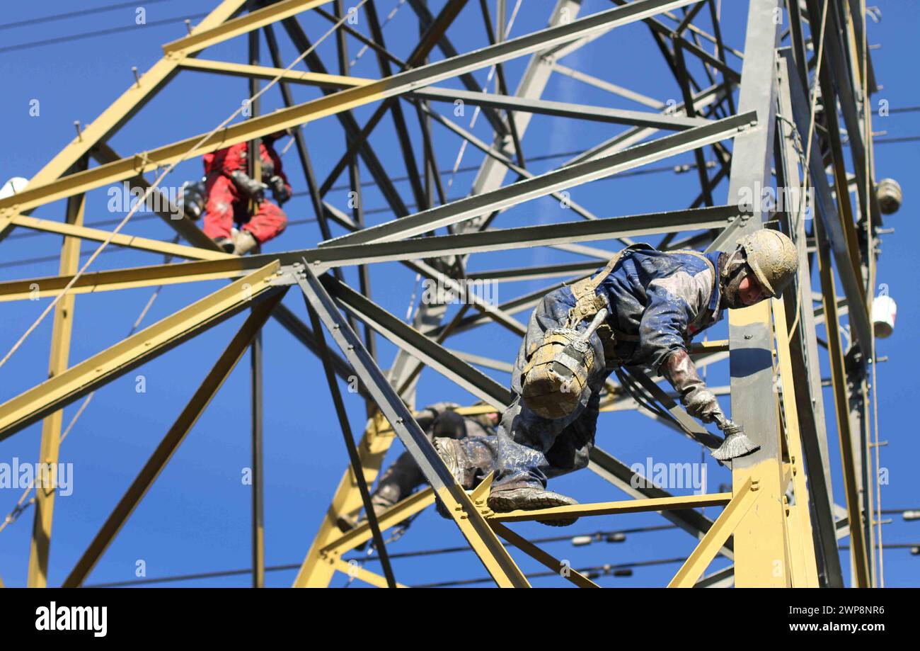 29/11/12 Workmen paint high voltage electricity pylons near Alderley ...