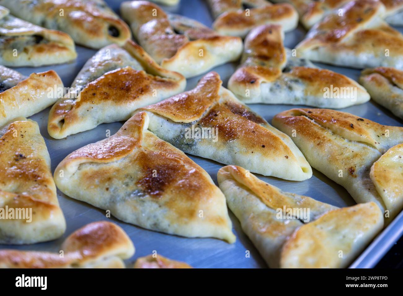 baked stuffed pastries on black marble background ready to be served ...