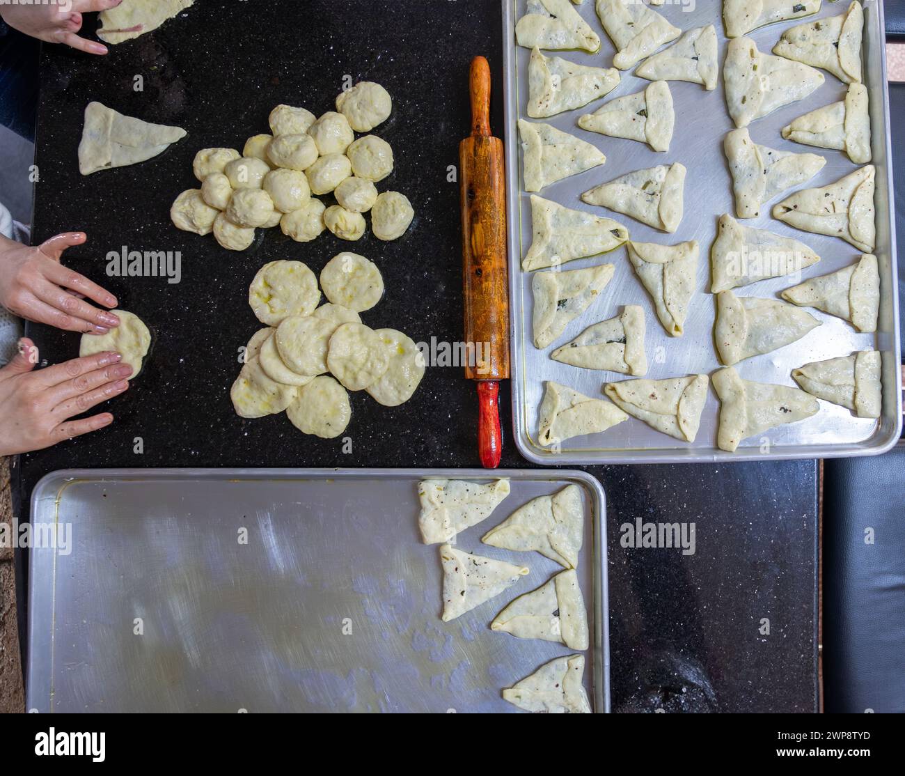 mother and daughter are working together preparing pastries for dinner ...