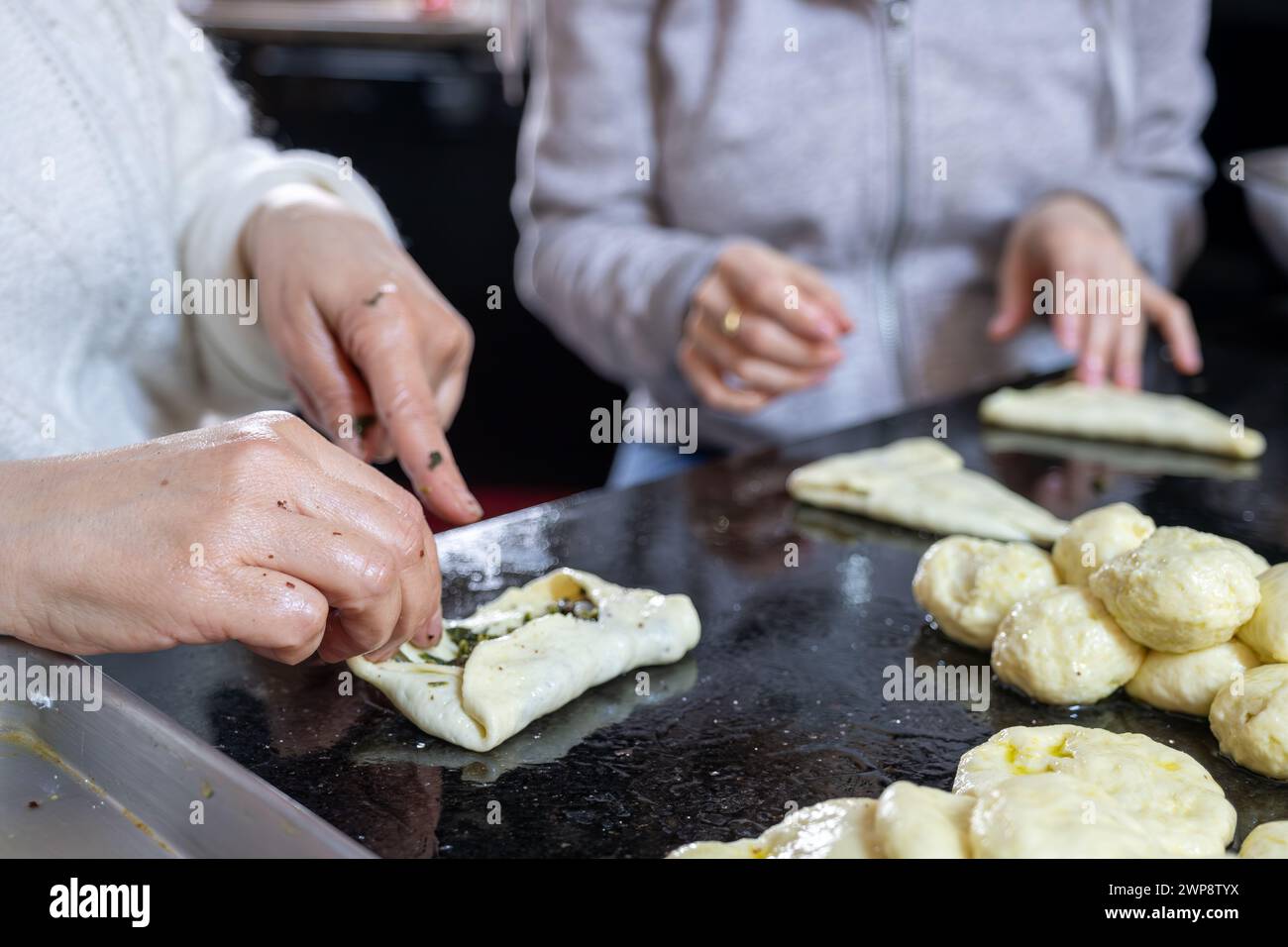 preparing arabic traditional pastries by female hands stuffing them ...