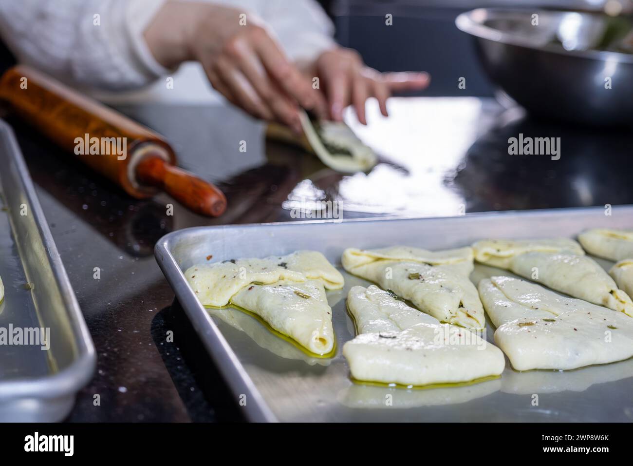 preparing arabic traditional pastries by female hands stuffing them ...