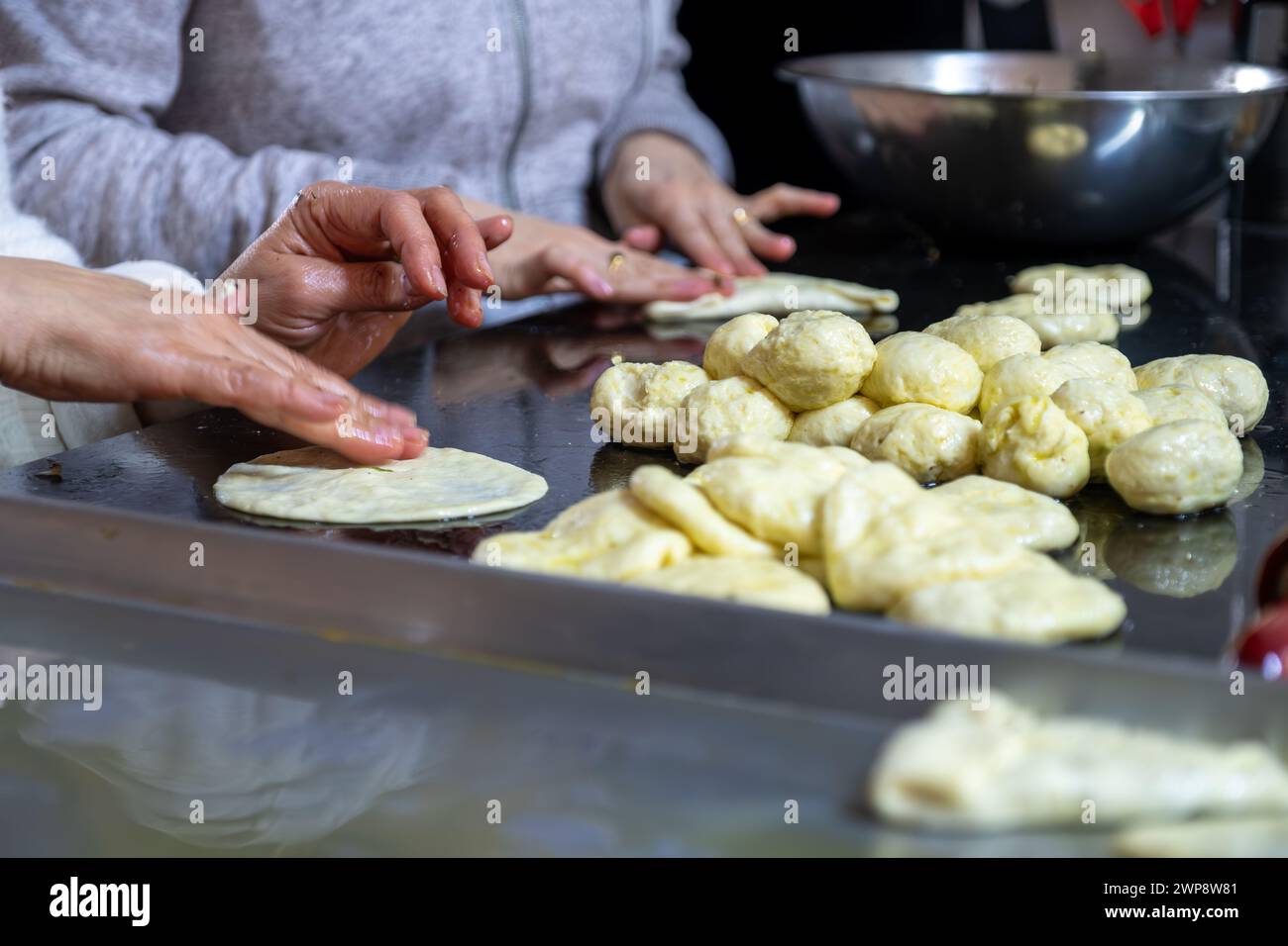 preparing arabic traditional pastries by female hands stuffing them ...