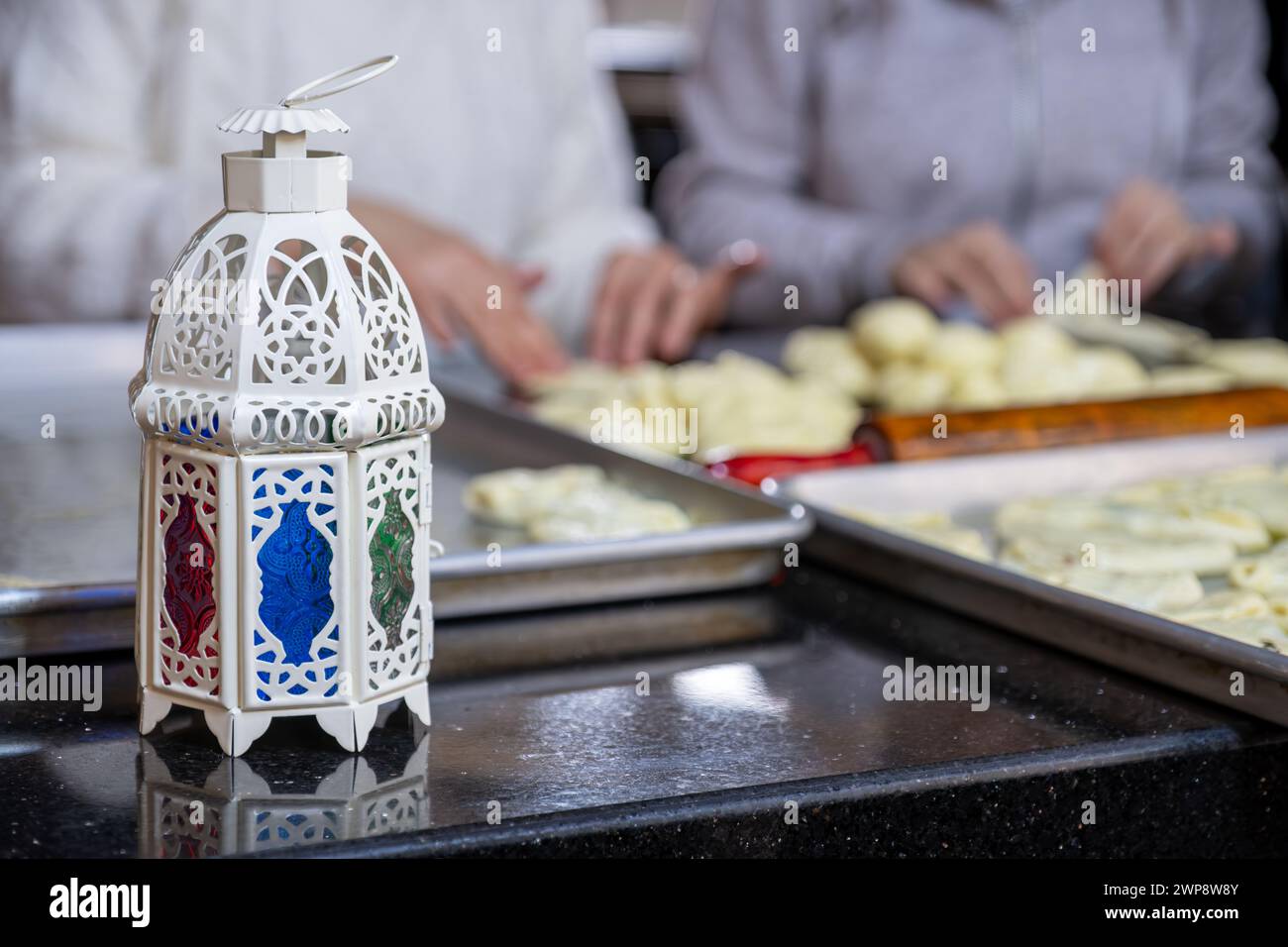 mother and daughter are working together preparing pastries for iftar ...