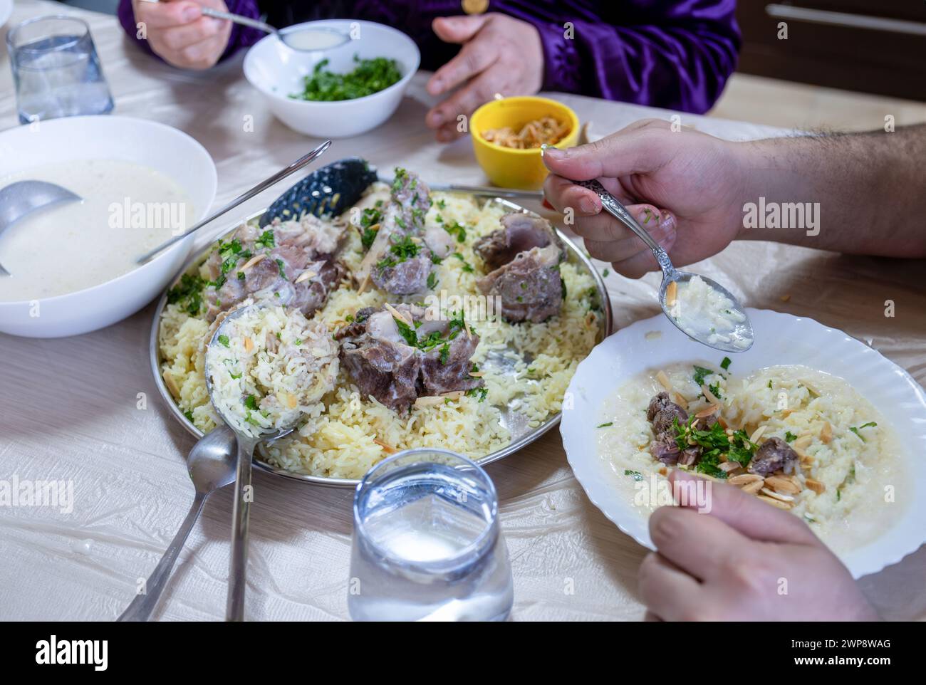 Family eating mansaf on dinner for iftar Stock Photo - Alamy