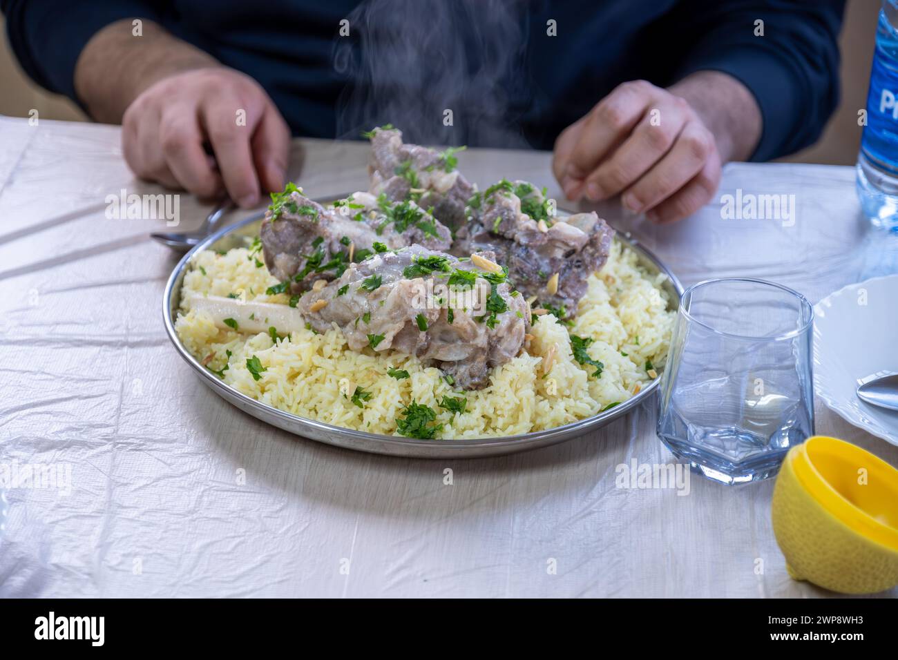 hot fresh mansaf steam with hands around it ready to be eaten on family ...