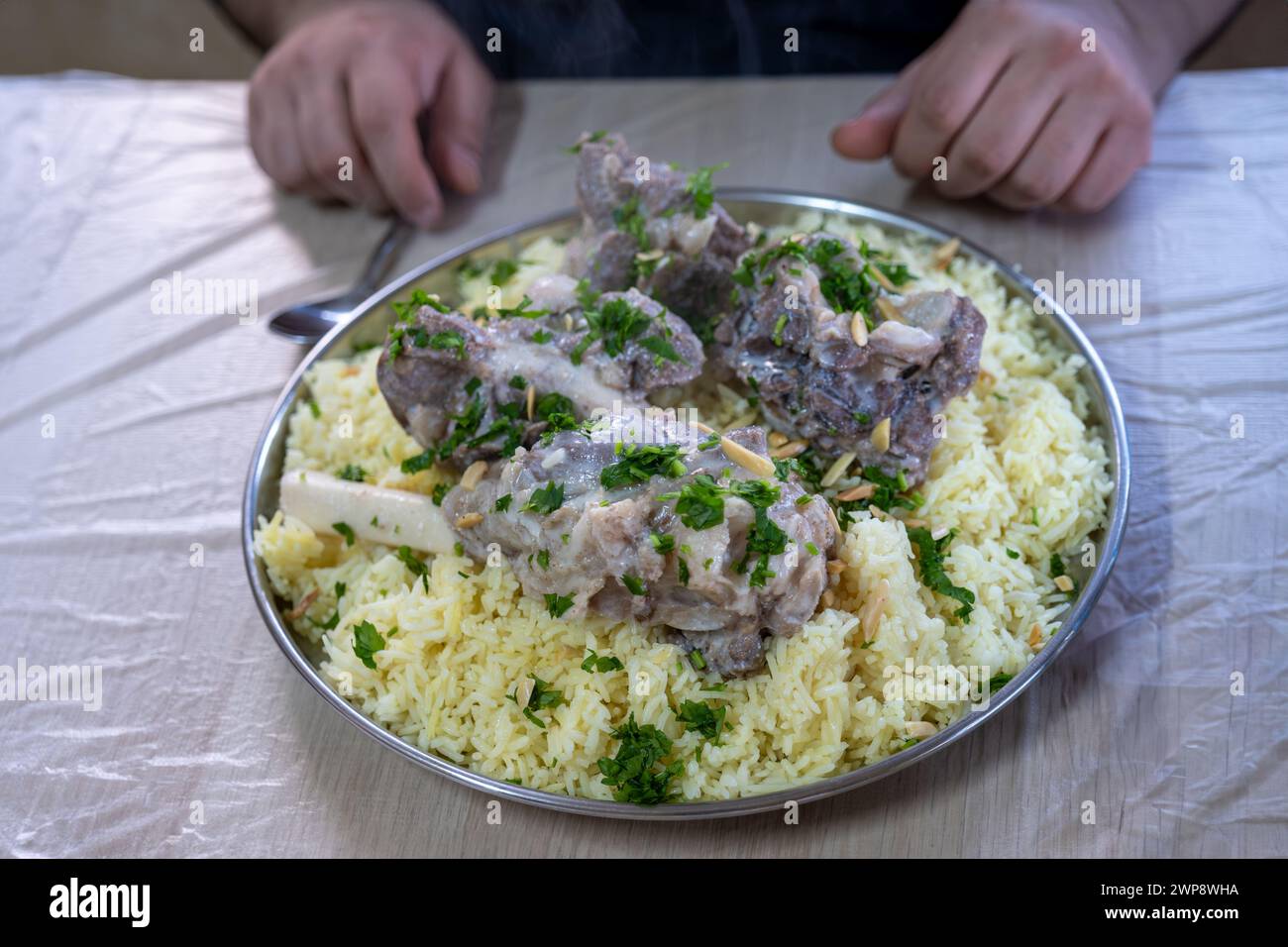 male hands with mansaf from a point of view while preparing his plate ...