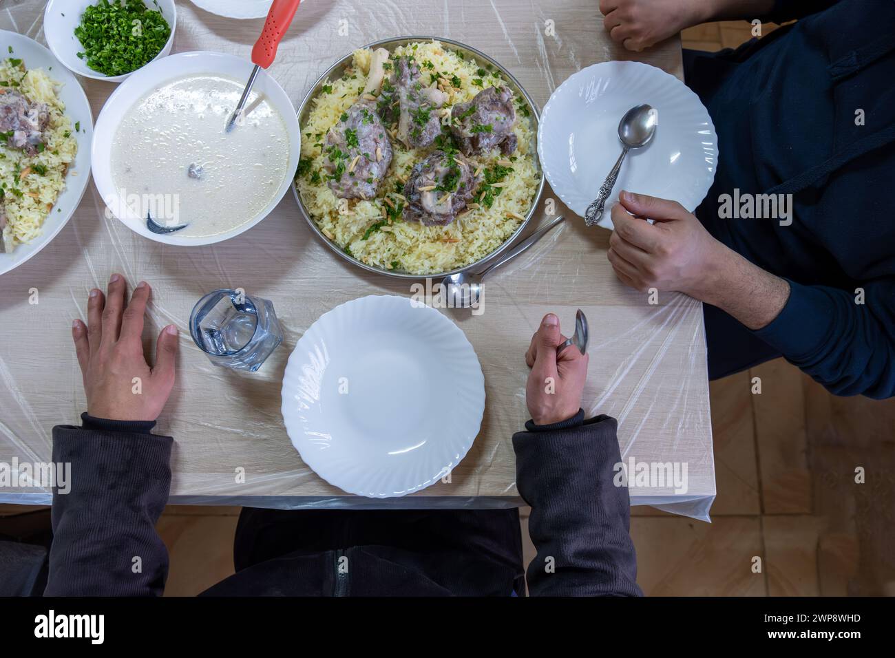 Family eating mansaf on dinner for iftar Stock Photo - Alamy