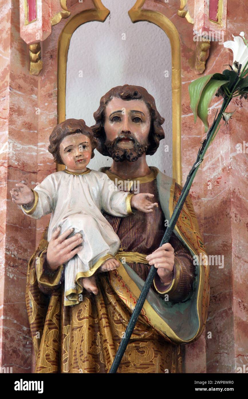 Saint Joseph holding child Jesus, statue on the High altar in the parish church of Saint Luke in ...