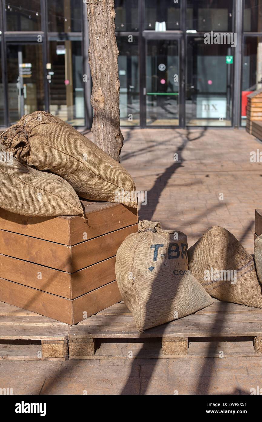 Barcelona, Spain - March 06, 2024: Jute sacks and a wooden barrel on a ...