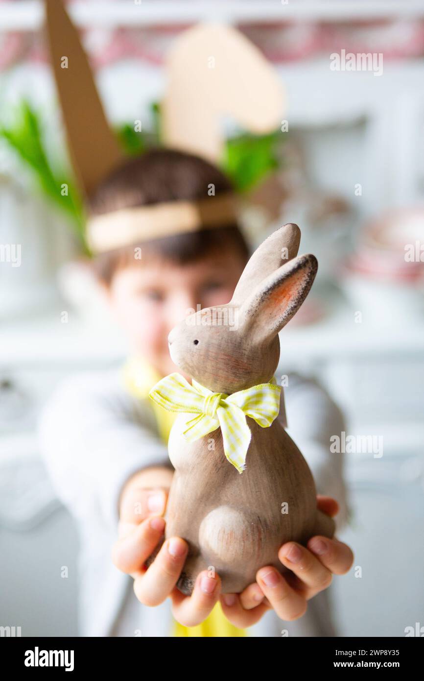 3 March 2024: A little boy holds a wooden Easter bunny in his hands ...