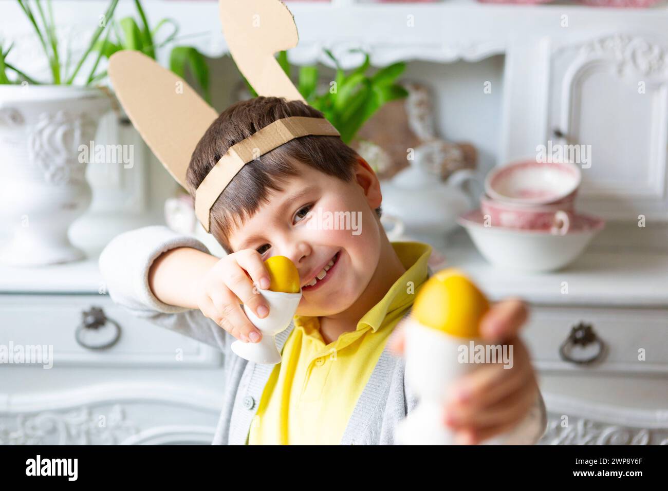 3 March 2024: Little boy playing with yellow colored Easter eggs. Happy ...
