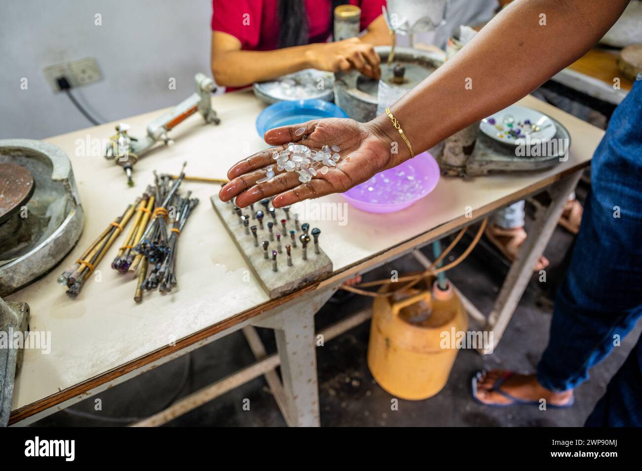 Woman shows machined precious stones (moonstone) in mine. Jewelry ...