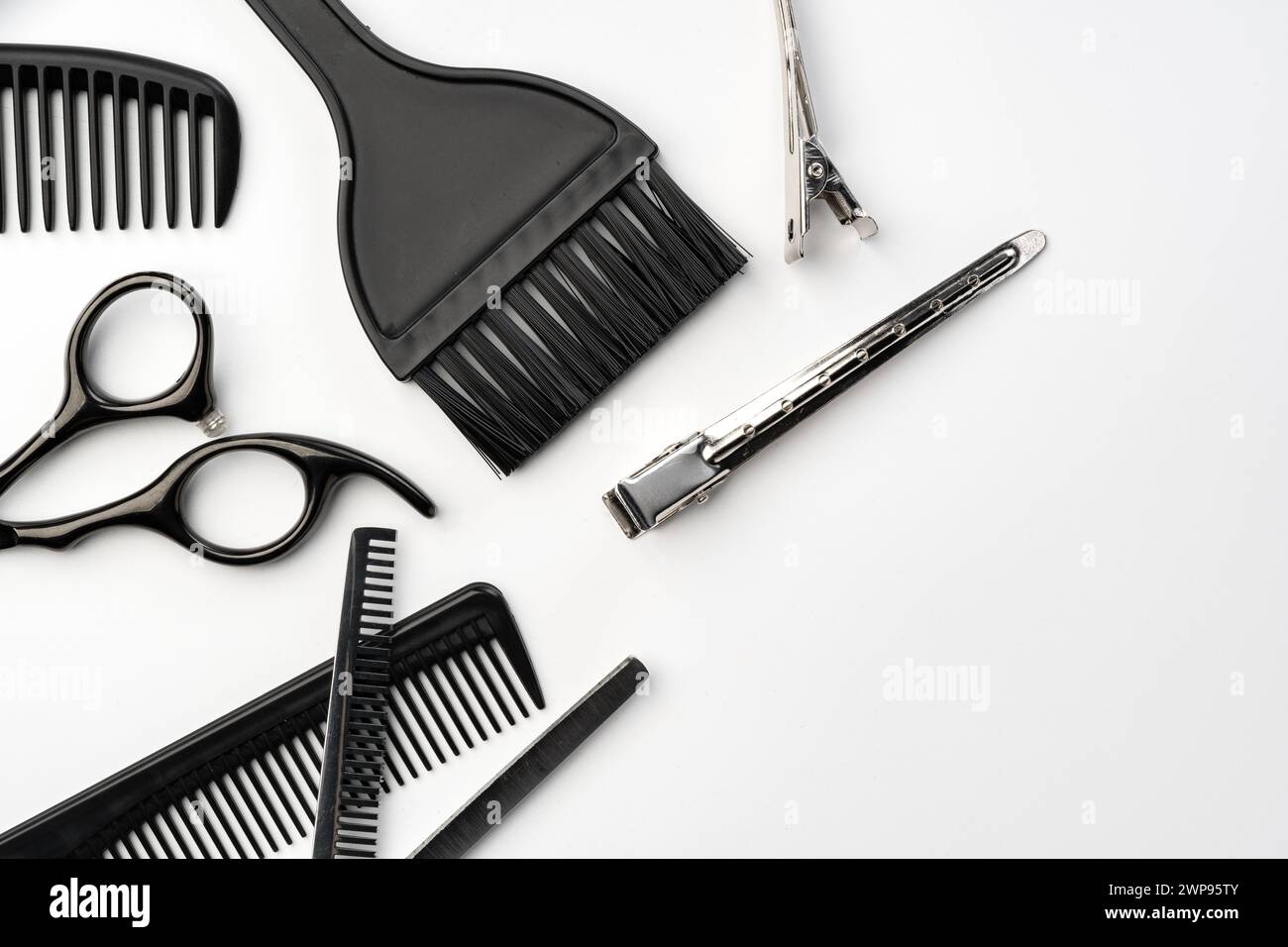 Black hairdressing tools and various hairbrushes on white background ...