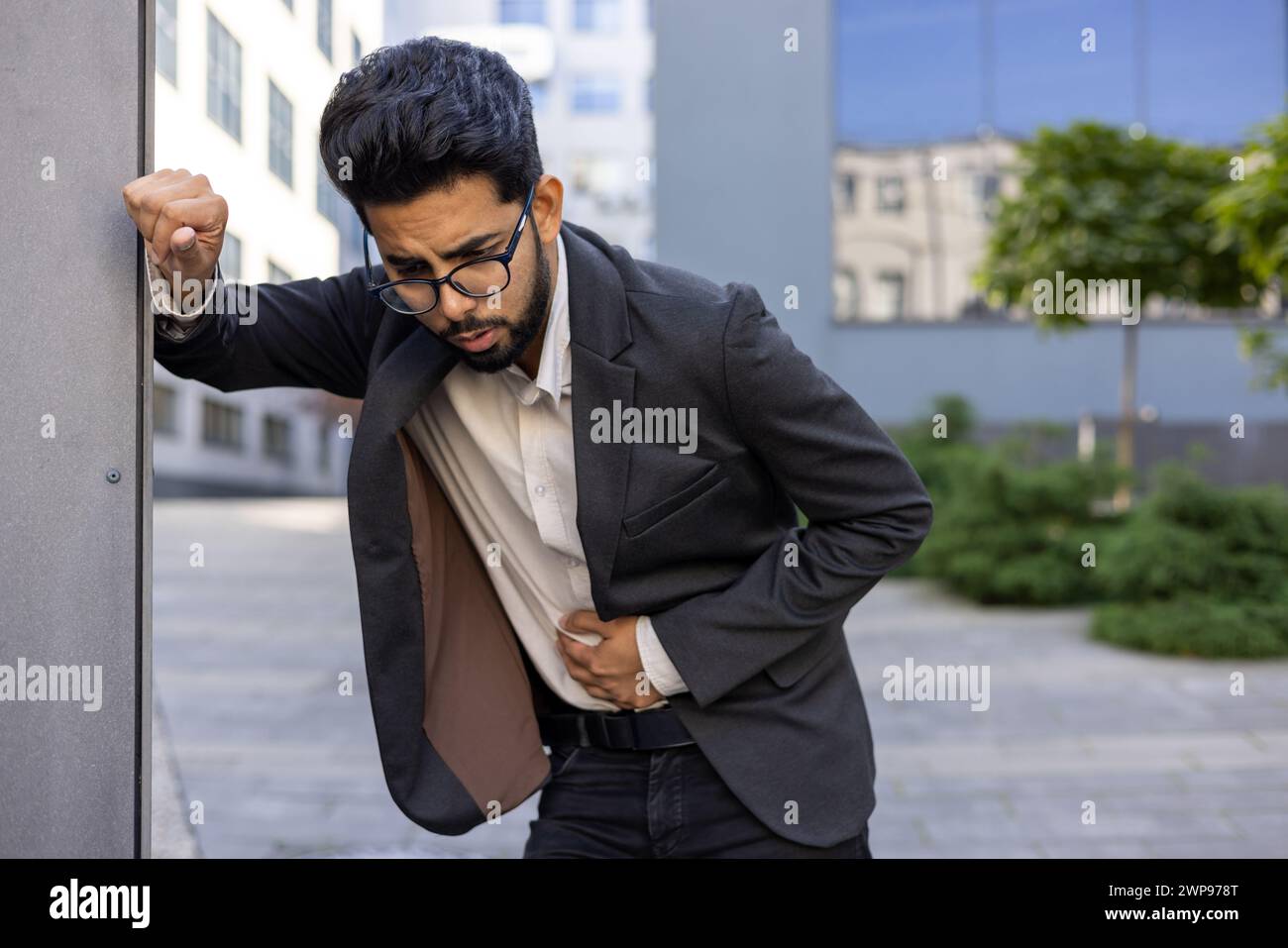 A young professional Indian man in smart-casual business attire ...