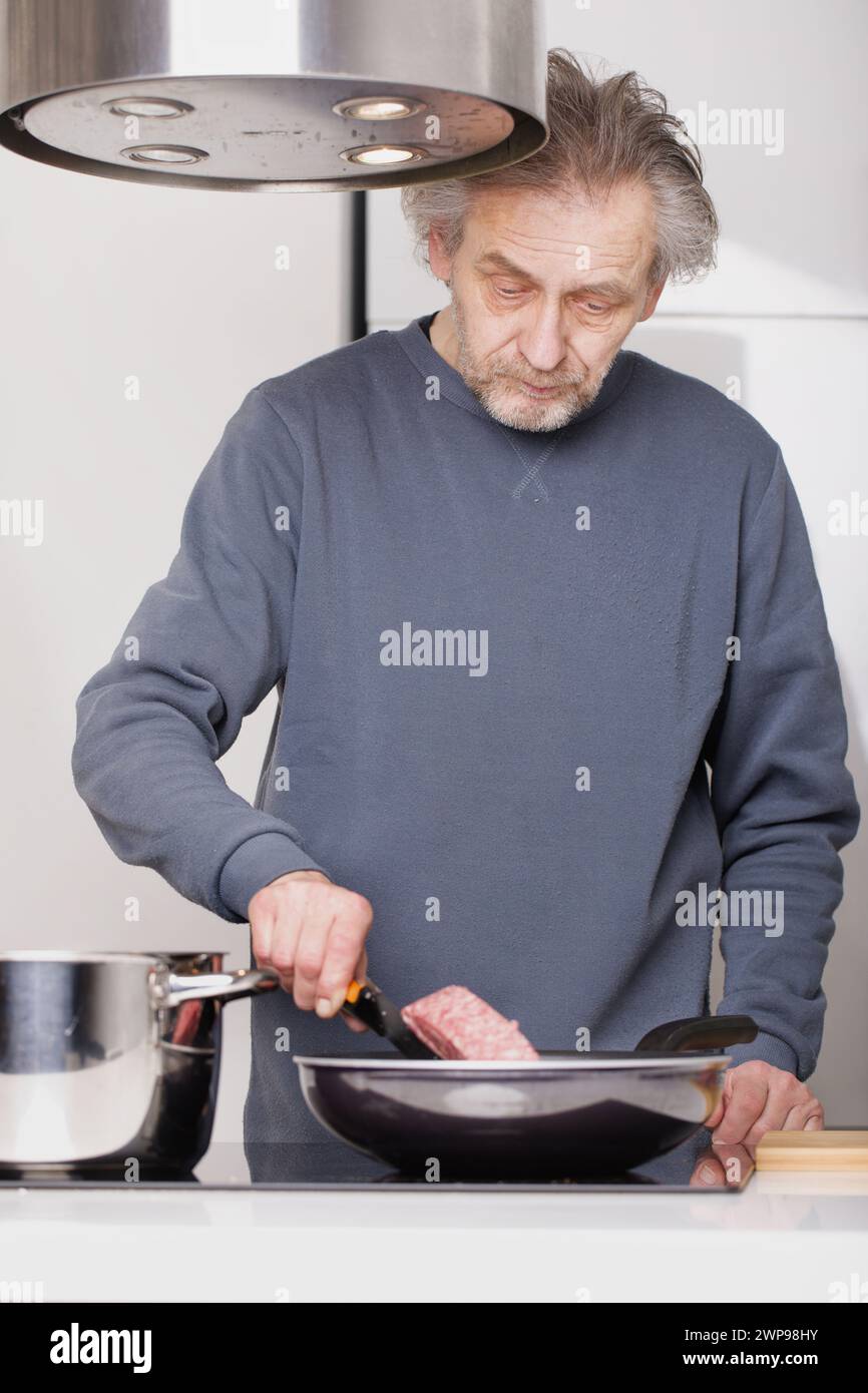 Man boiling meat in pot hi-res stock photography and images - Alamy