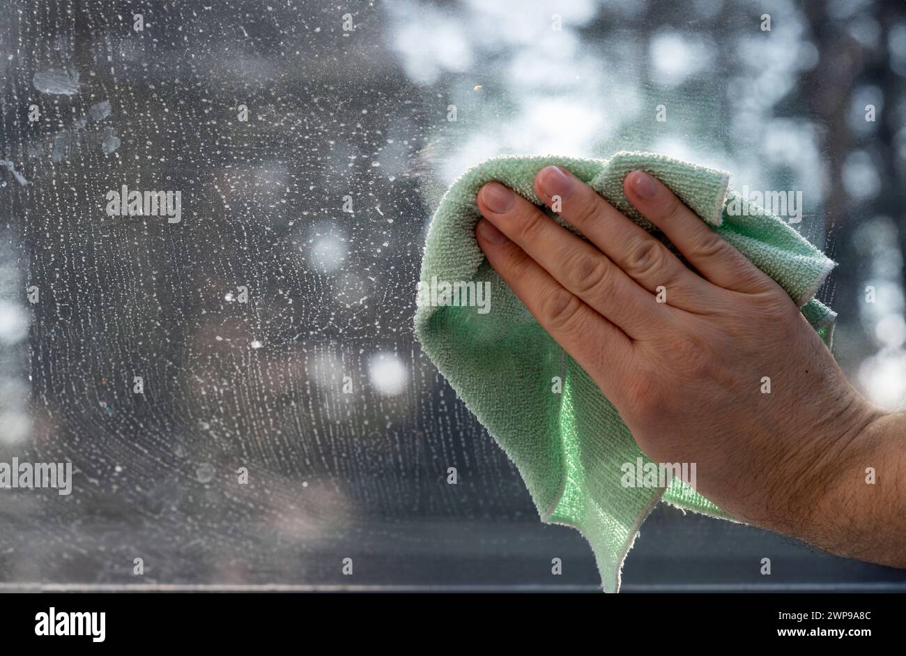Man cleans dirty window with a cloth during sunshine Stock Photo - Alamy