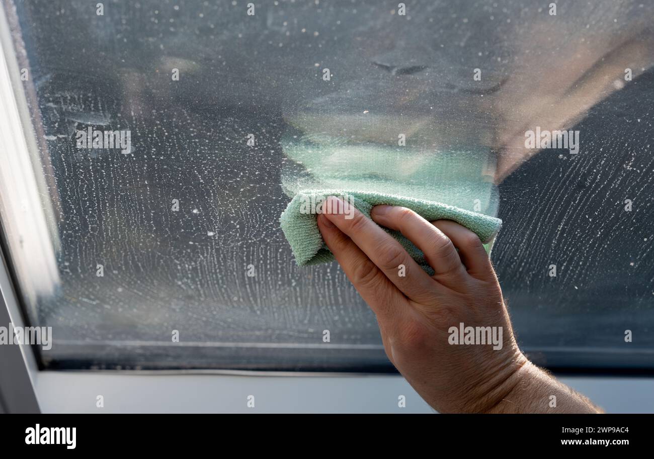 Man cleans dirty window with a cloth during sunshine Stock Photo - Alamy