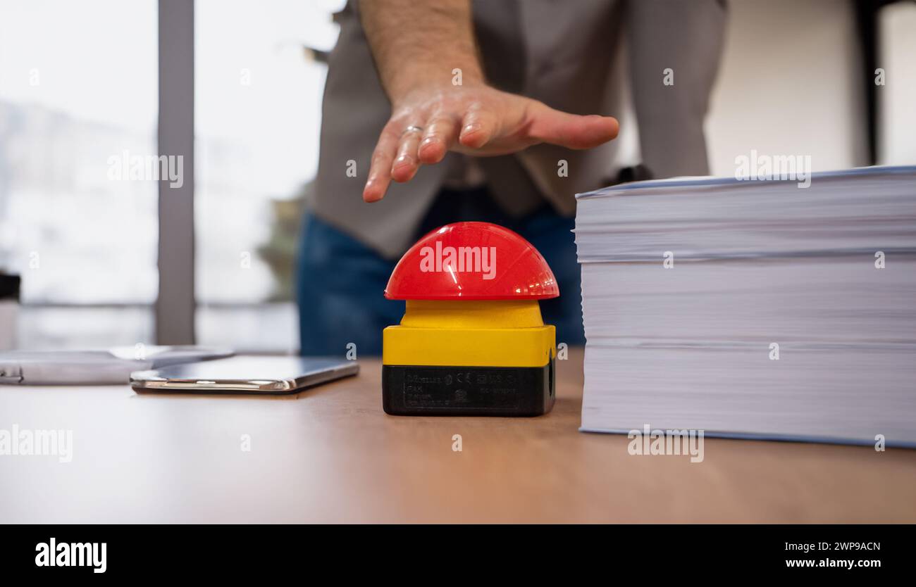 Man pressing the emergency button in a office full of paperwork. Symbol ...