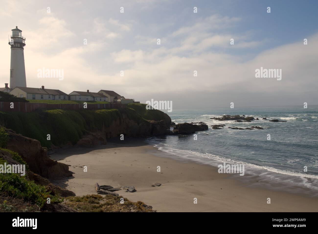 Cove with lighthouse above Pacific Ocean Stock Photo - Alamy