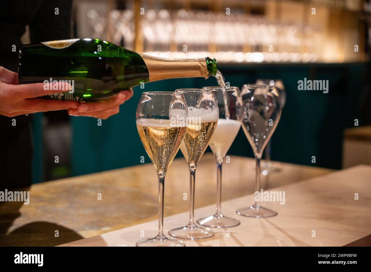 Pouring and tasting of dry sparkling wine champagne on winter weekend ...