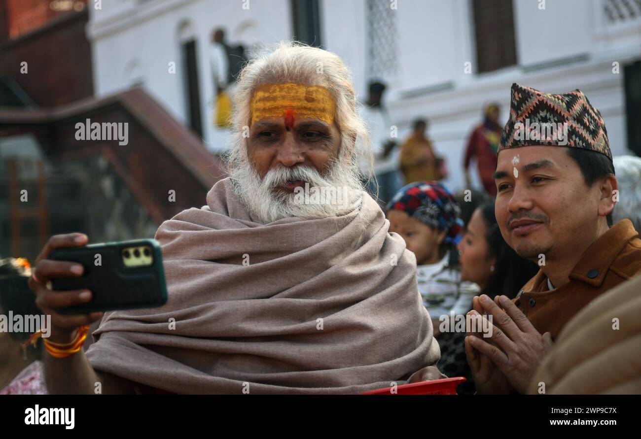 Kathmandu, Nepal. 6th Mar, 2024. A holy man (sadhu) takes a selfie with a devotee ahead of the ...