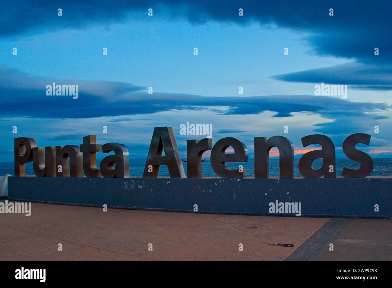 Evening light on the metal Punta Arenas sign near the shore. The sign ...