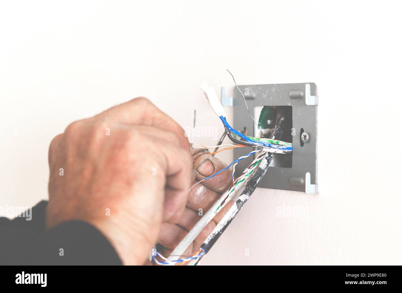 Electrician's hands when installing the socket and connecting the ...