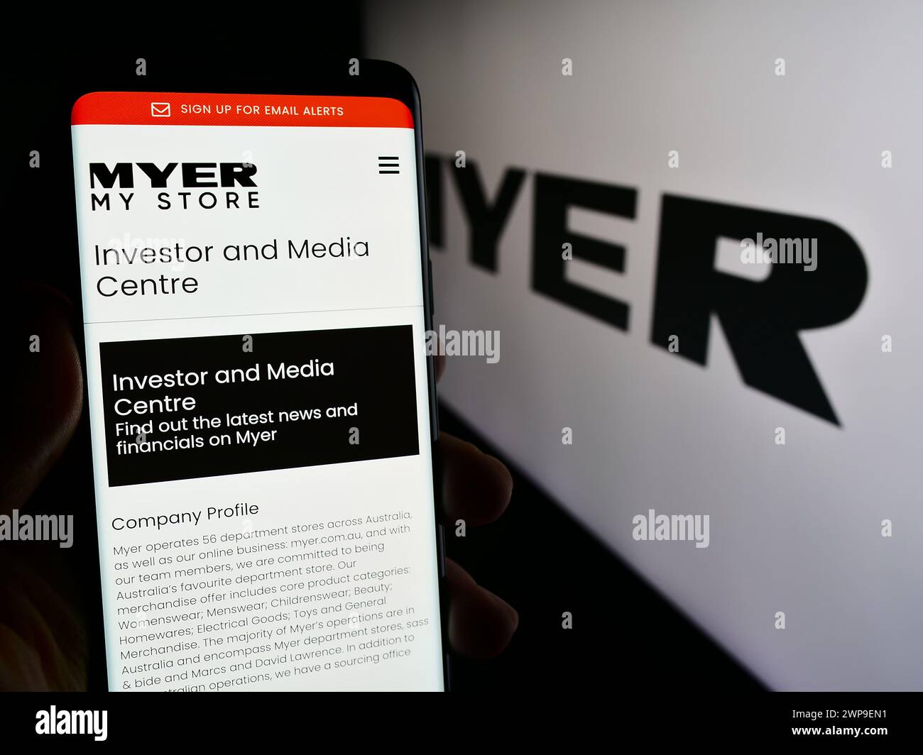 Person holding cellphone with web page of Australian retail company ...