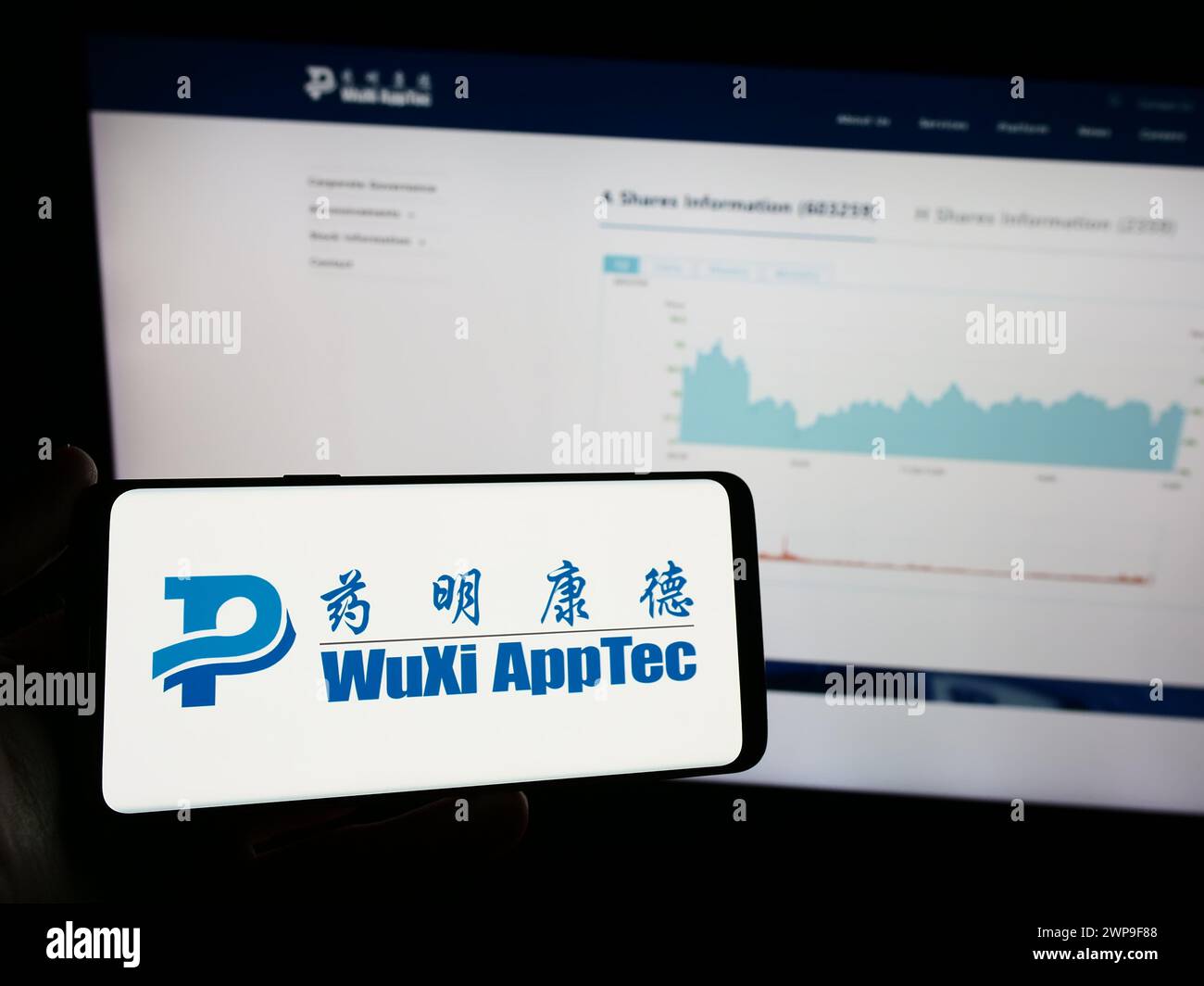 Person holding mobile phone with logo of Chinese pharmaceutical company ...