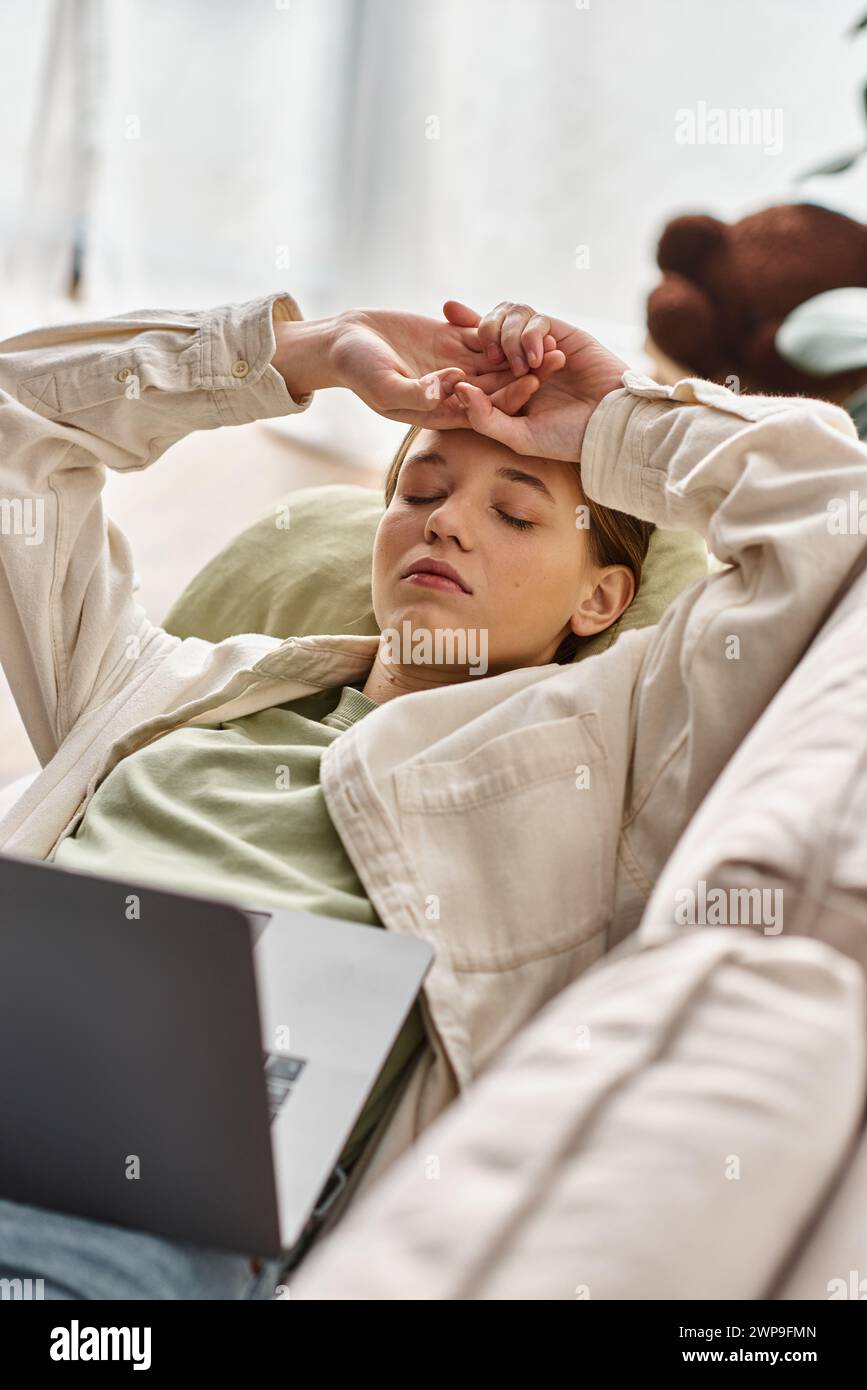 tired gen z teenage girl sleeping with her laptop on comfortable couch ...
