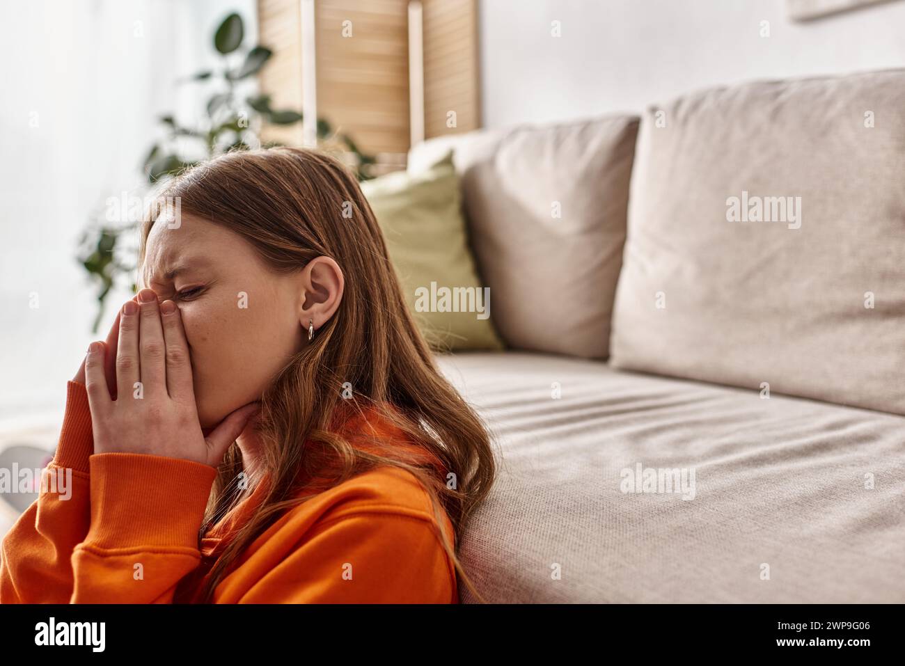 Teenage girl in distress, covering face with hands while crying near ...