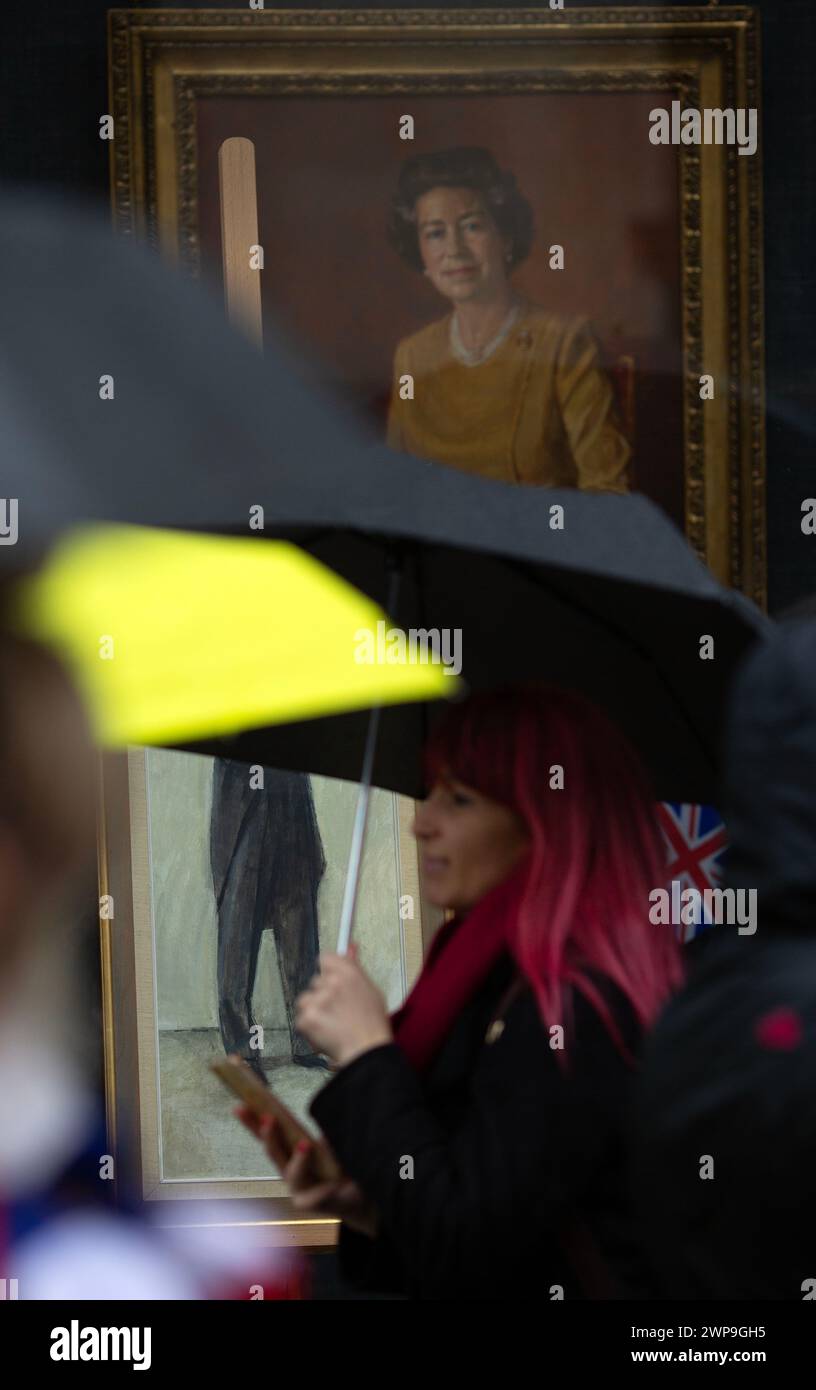 Portraits of King Charles III and late Queen Elizabeth II are seen in a ...