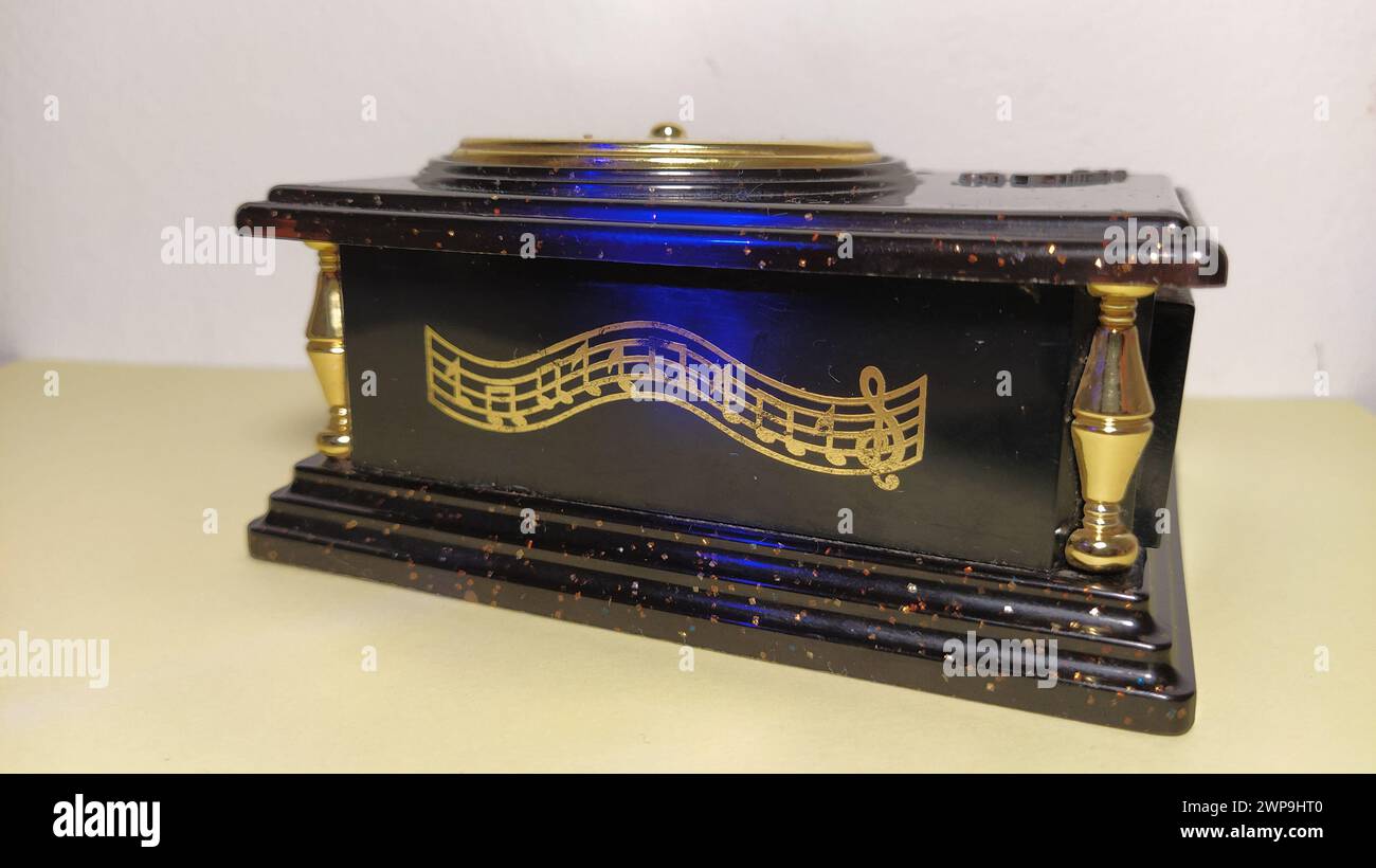 Old black music box. The notes are painted on the front side of the ...