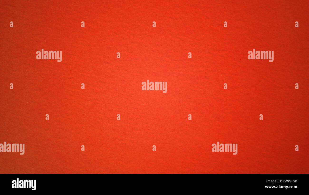 A sheet of bright red paper with light vignetting around the edges ...