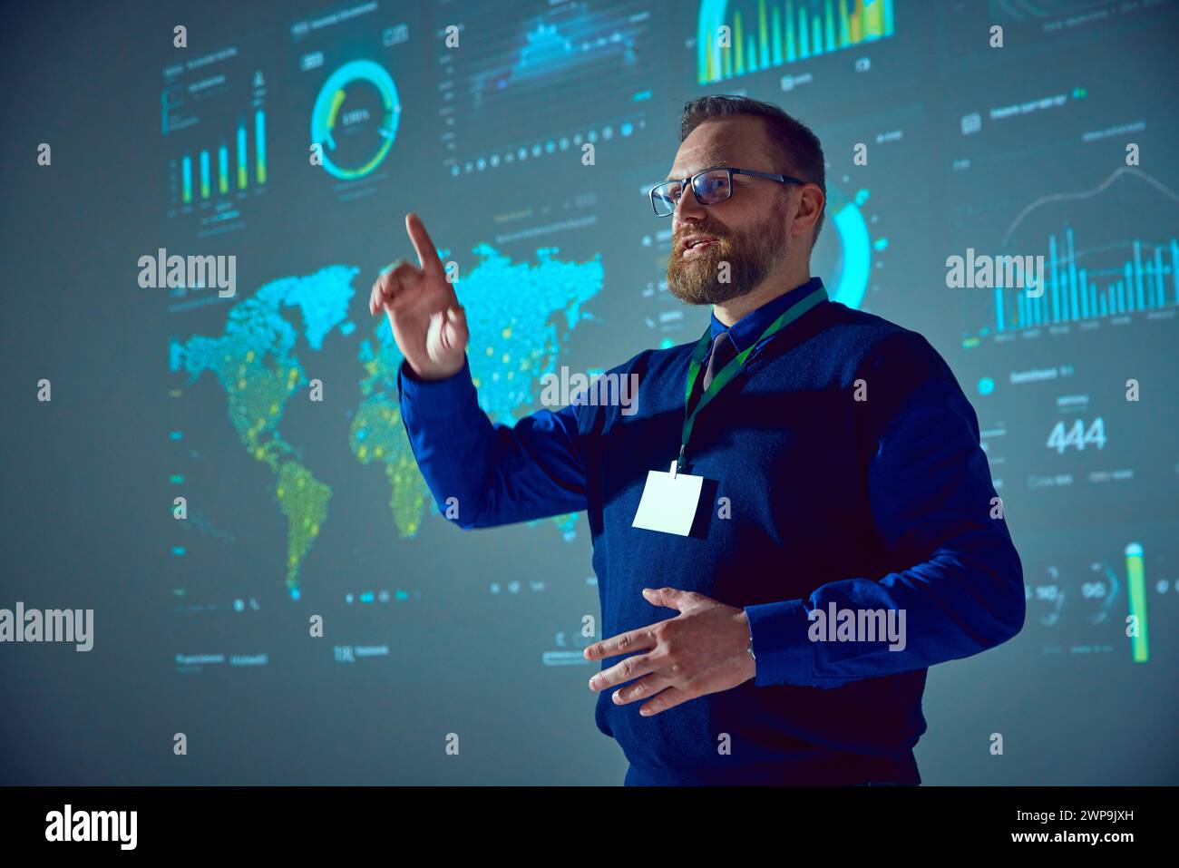 Speaker, lecturer stands near presentation board with graphs, maps and ...