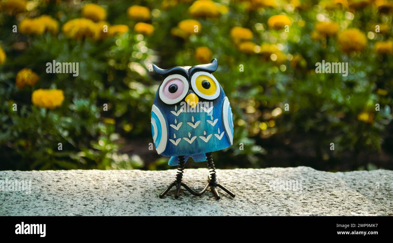 A toy of a surprised blue-colored owl with multi-colored eyes close-up ...