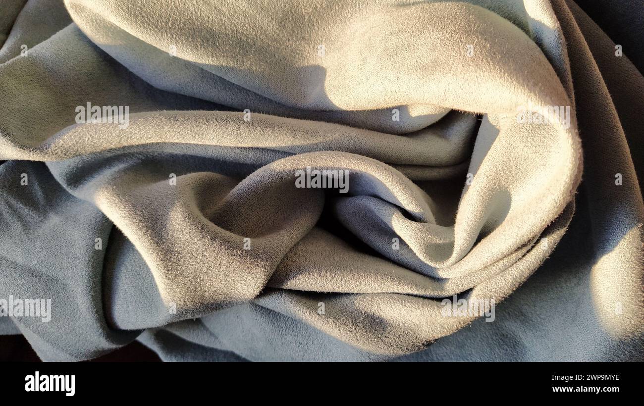 Gray-blue velvet curtains in the living room. The fabric is folded into ...